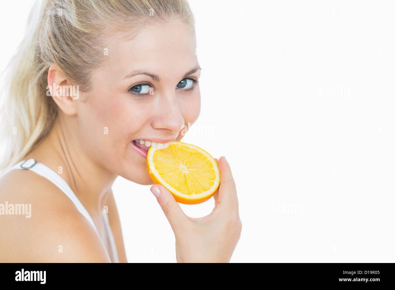 Happy woman biting slice of orange Stock Photo - Alamy