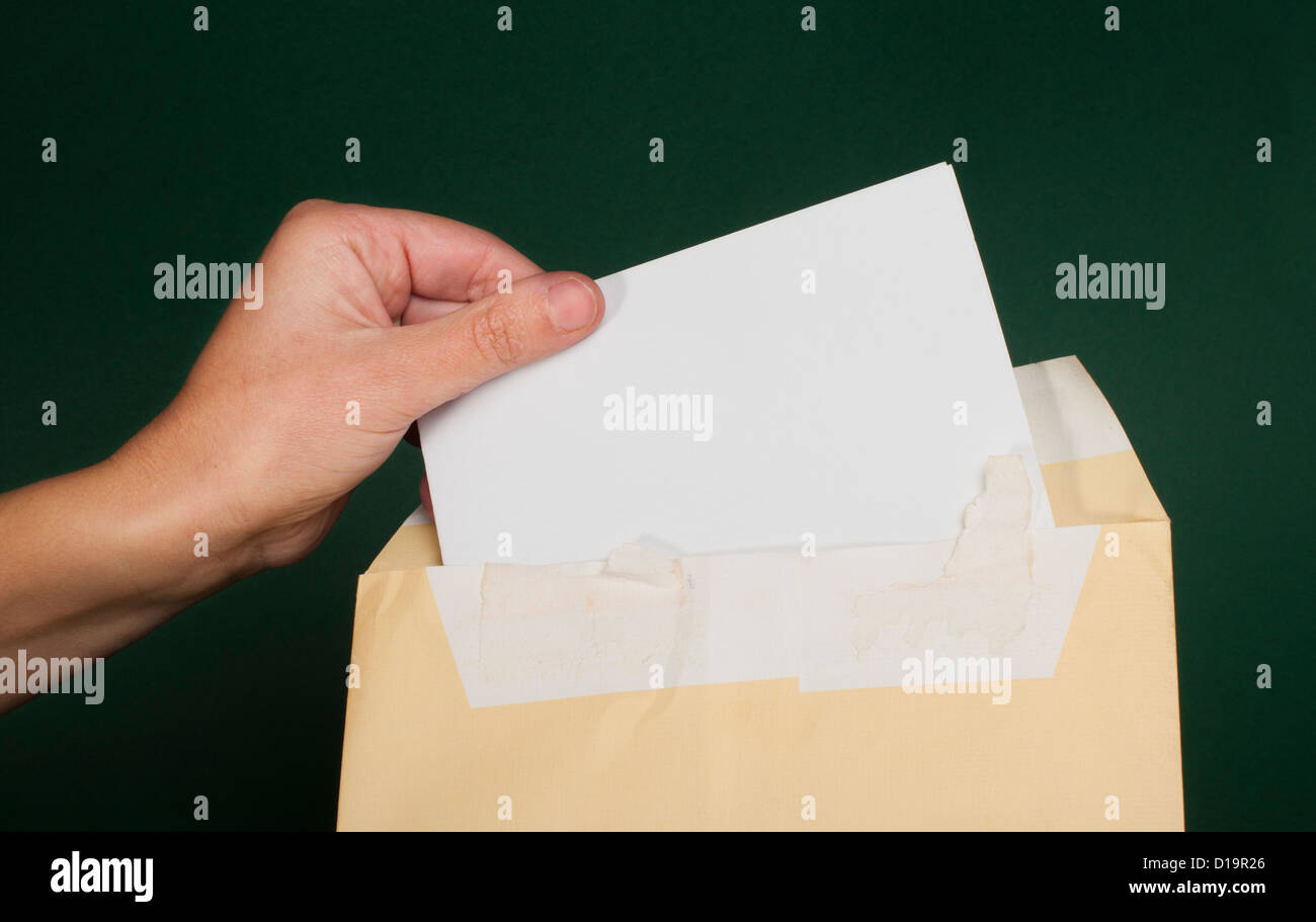Hand that open a letter from brown envelope. Dark green background ...