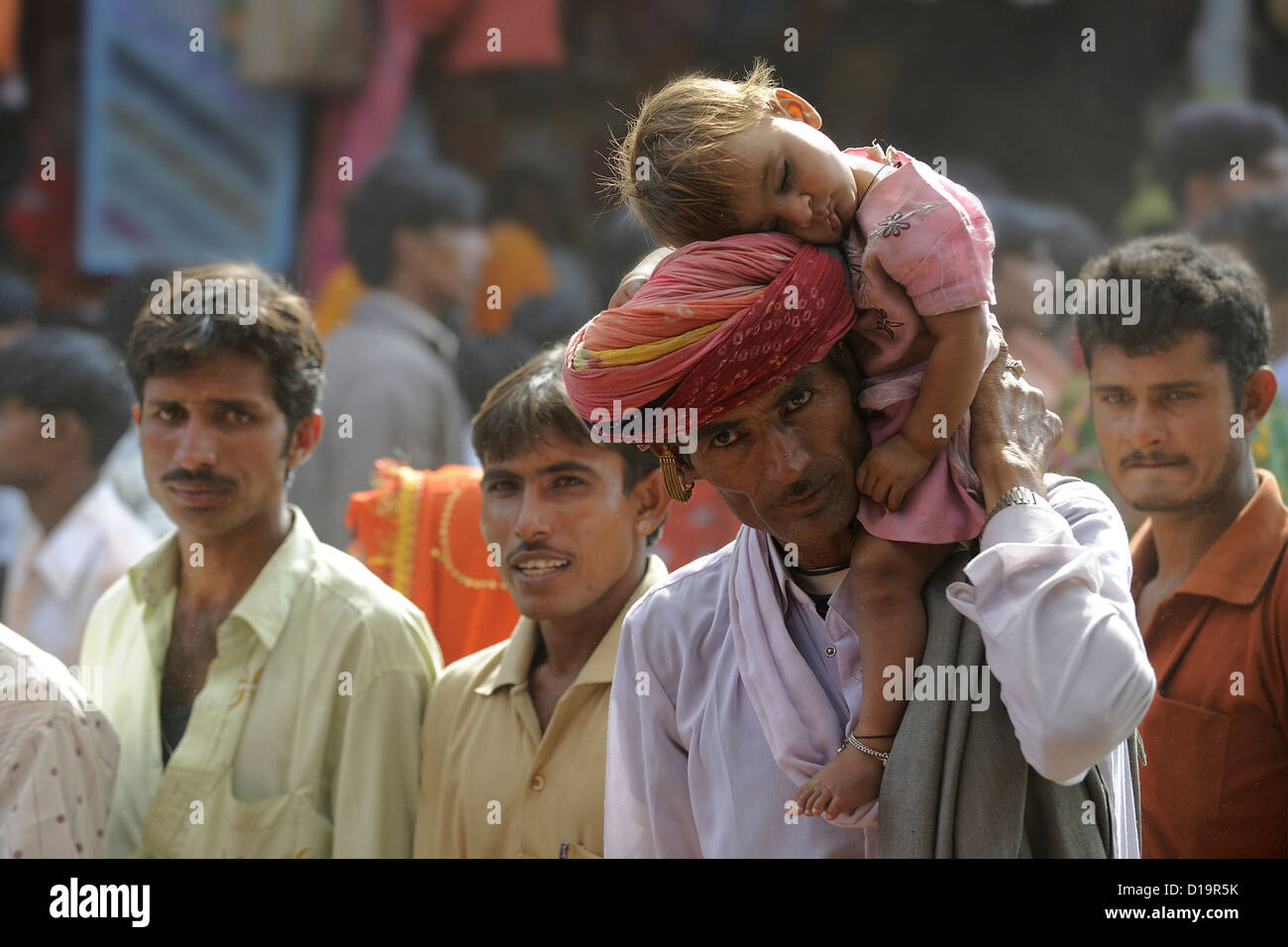 Indian man carrying baby Stock Photo - Alamy