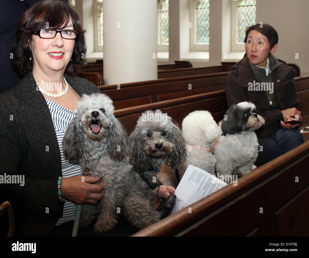 Two women with dogs during a Pet blessing ceremony in church. SE London ...