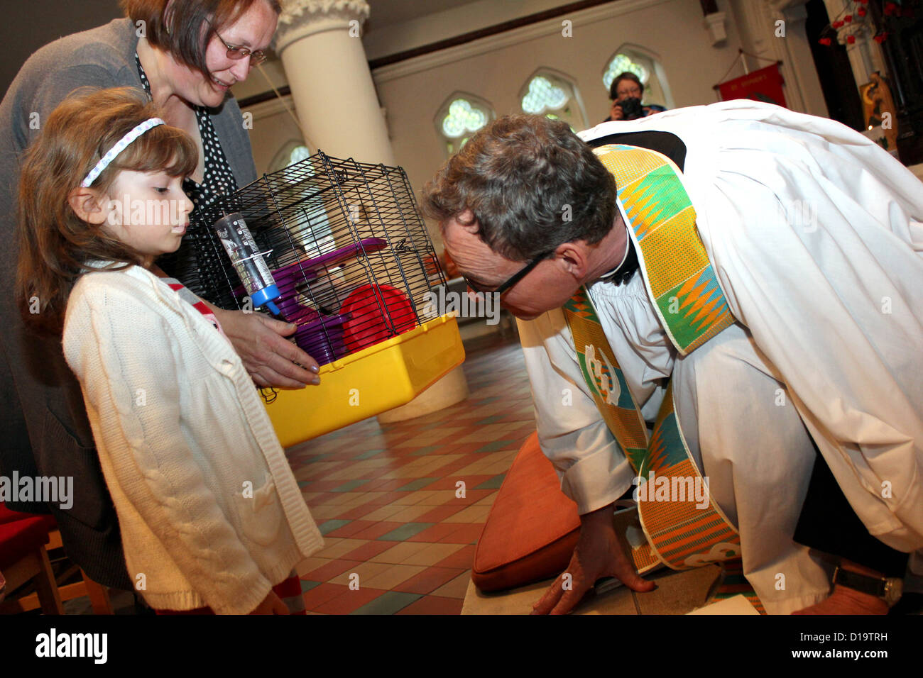 Priest blessing an animal during a pet blessing ceremony in church. SE ...