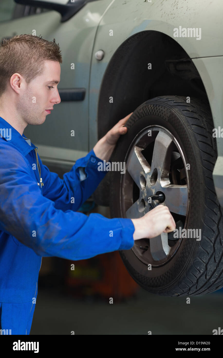 Mechanic changing car tyre Stock Photo - Alamy