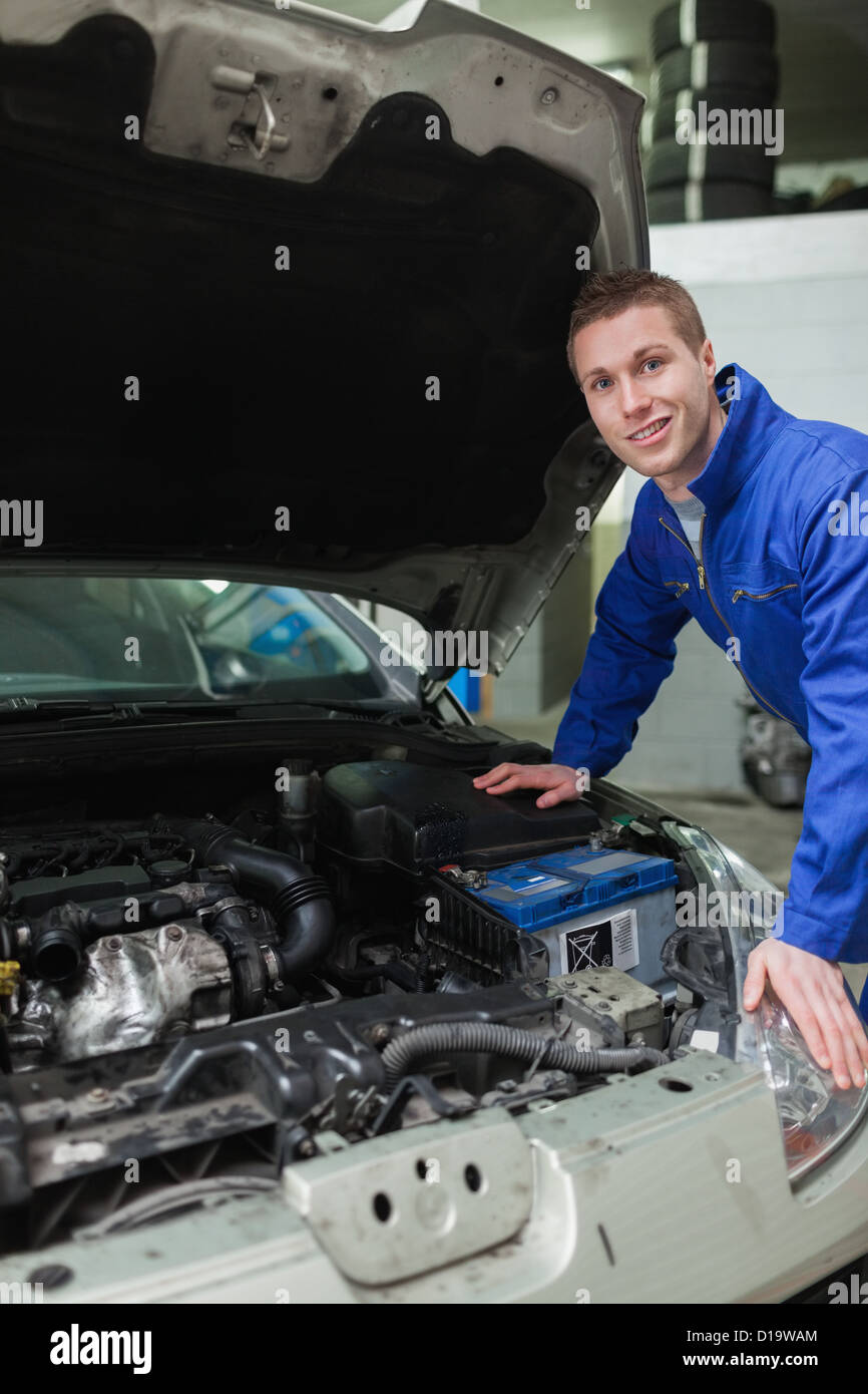 Happy mechanic repairing car engine Stock Photo - Alamy