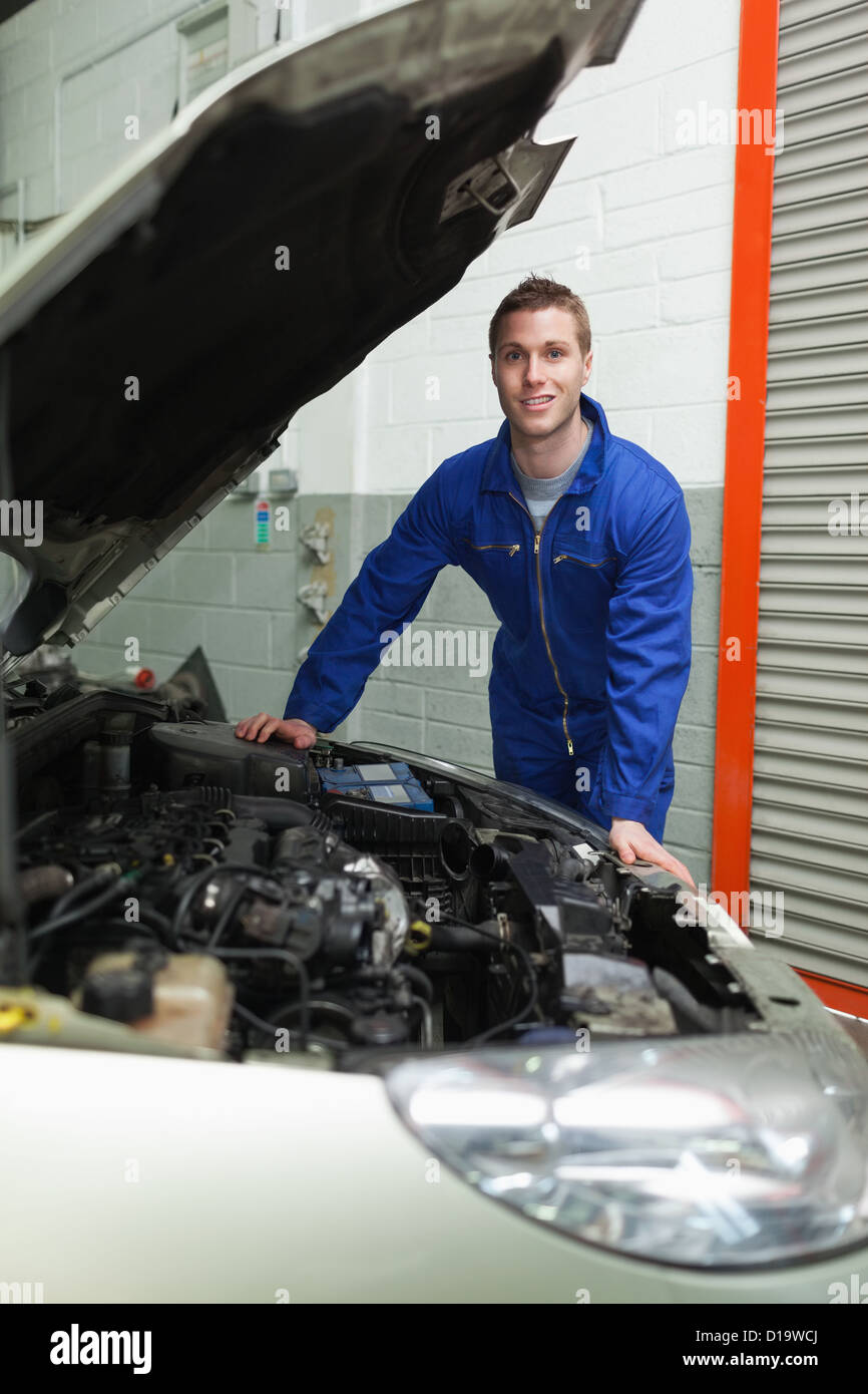 Happy mechanic standing by car Stock Photo - Alamy