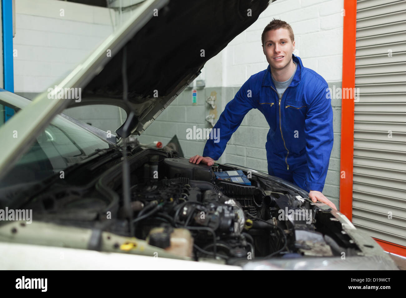 Repairman standing by car with open hood Stock Photo - Alamy