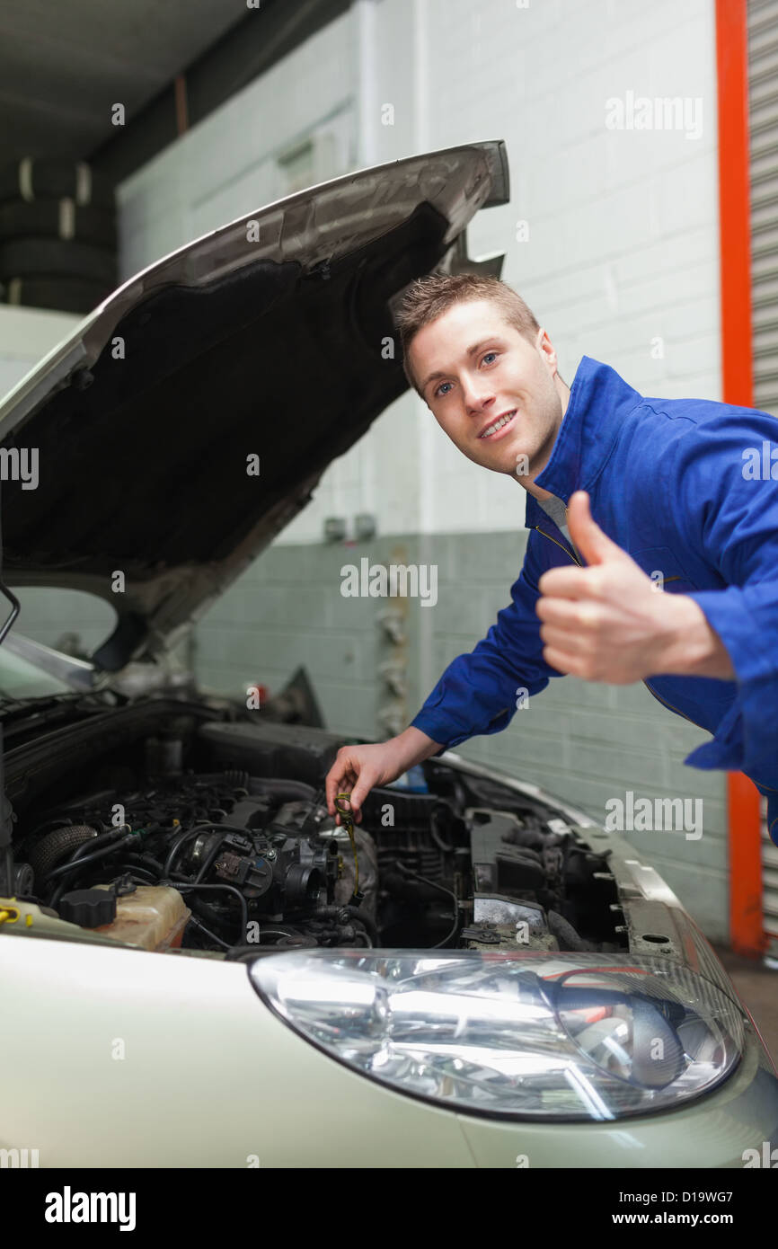 Auto mechanic by car gesturing thumbs up Stock Photo - Alamy