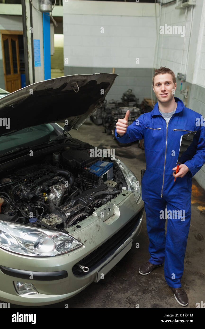 Mechanic by car showing thumbs up sign Stock Photo - Alamy