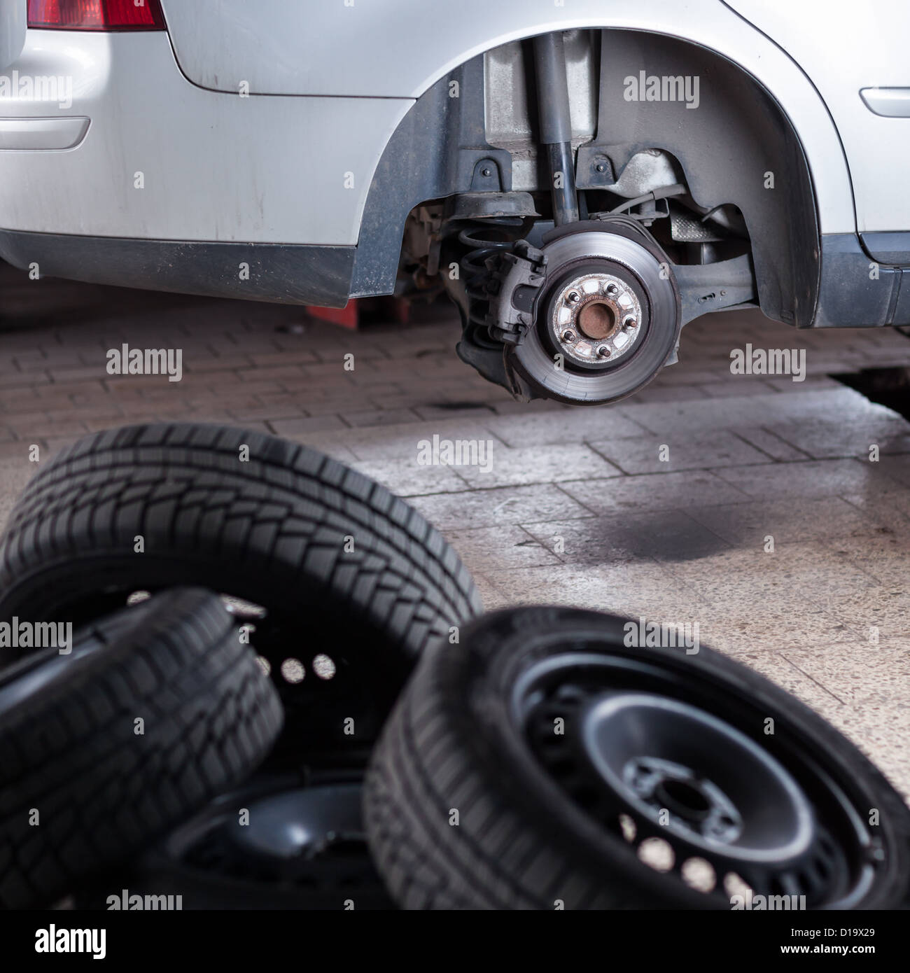 mechanic changing a wheel of a modern car (shallow DOF; color toned ...
