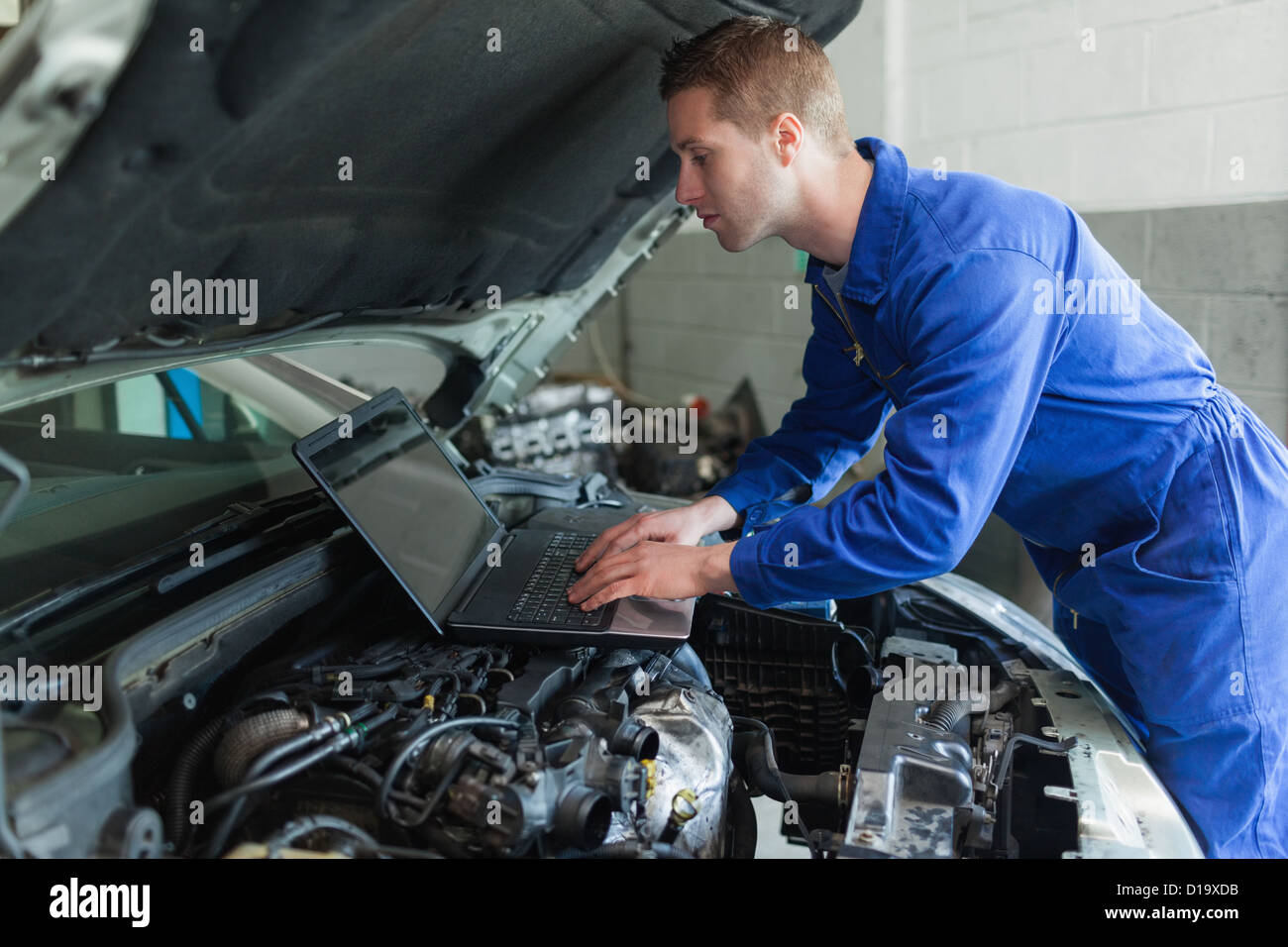 Auto mechanic working on laptop Stock Photo - Alamy