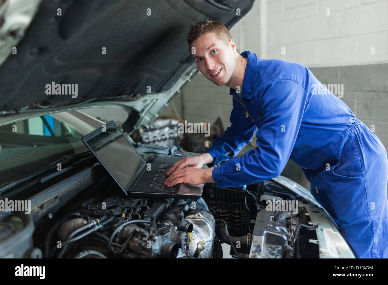 Male auto mechanic using laptop Stock Photo - Alamy