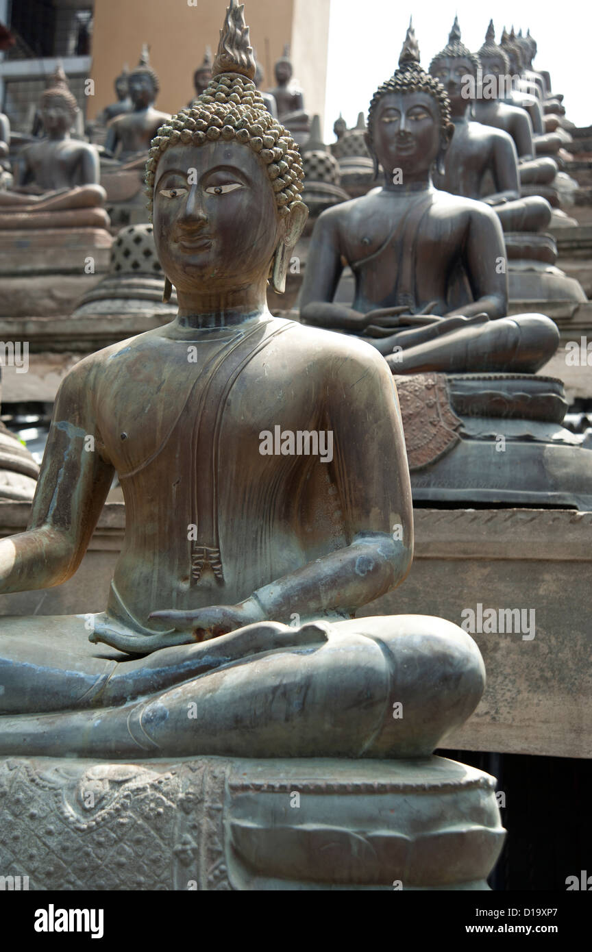 Bronze Buddha statues sit in line at a temple in Colombo Sri Lanka ...