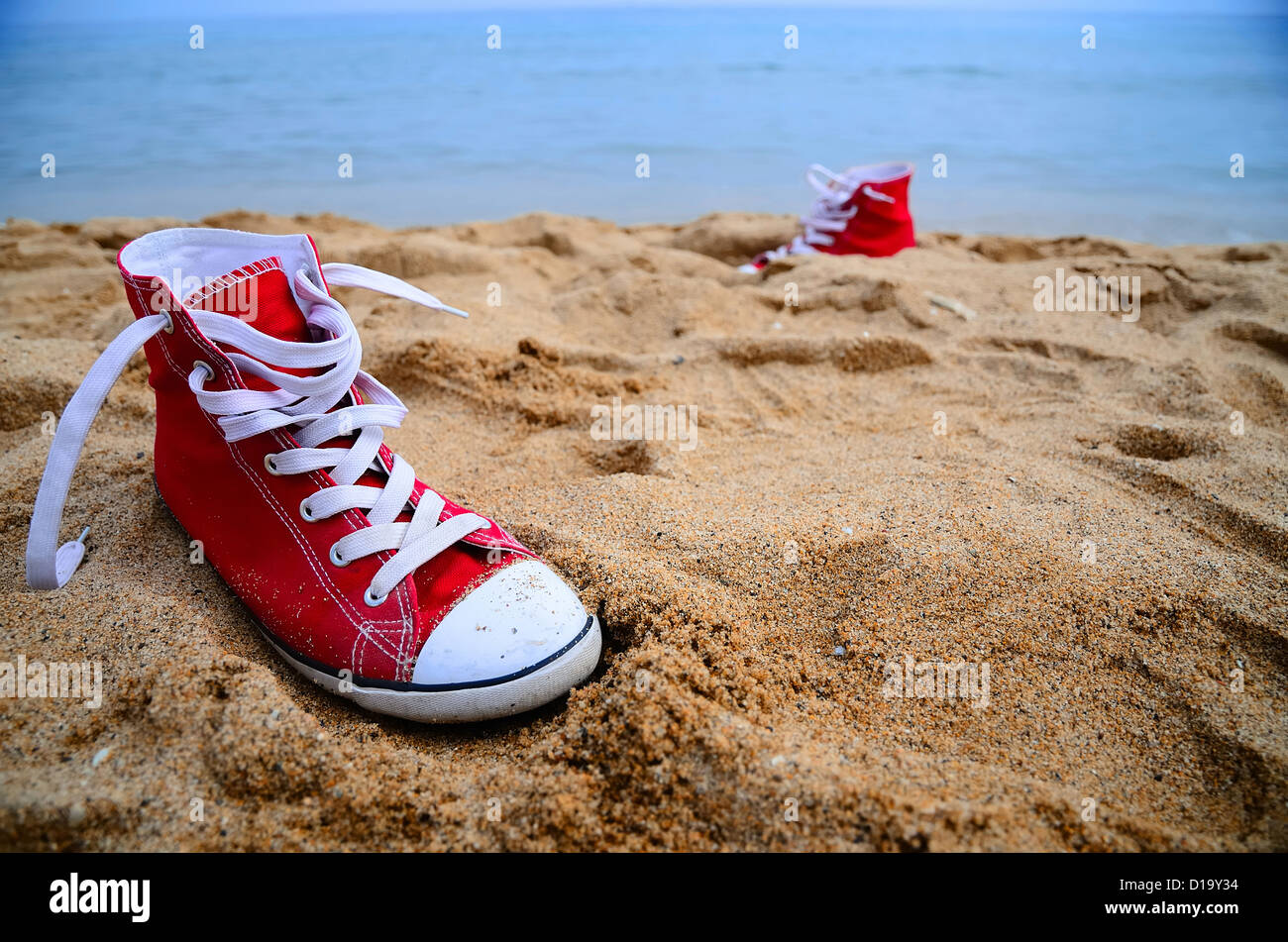 two sneakers on a beach Stock Photo - Alamy