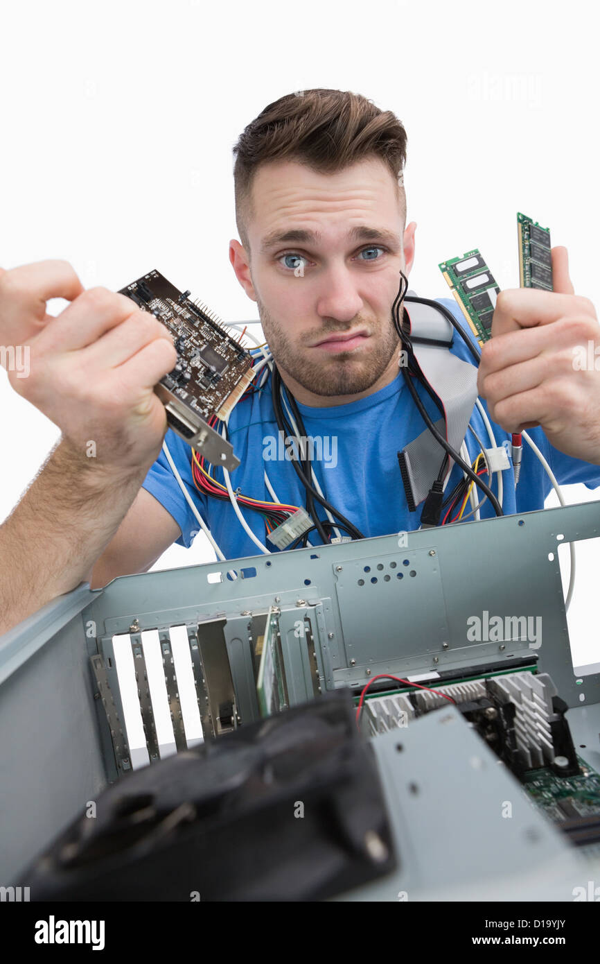Portrait of confused it professional with chips in front of open cpu ...