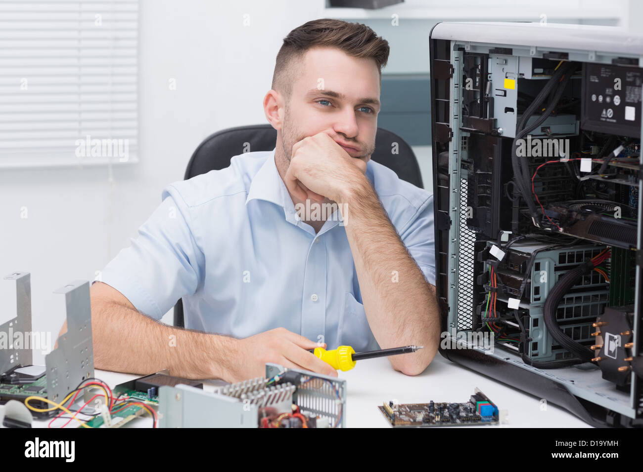 Thoughtful hardware professional sitting by an open cpu Stock Photo - Alamy