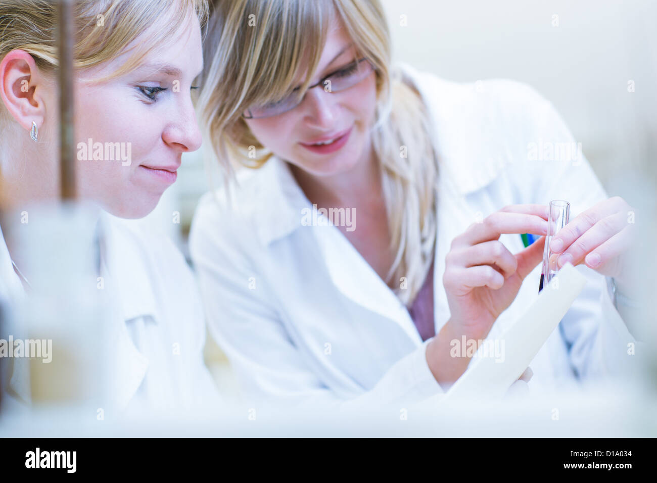 female researchers carrying out research together in a chemistry lab ...