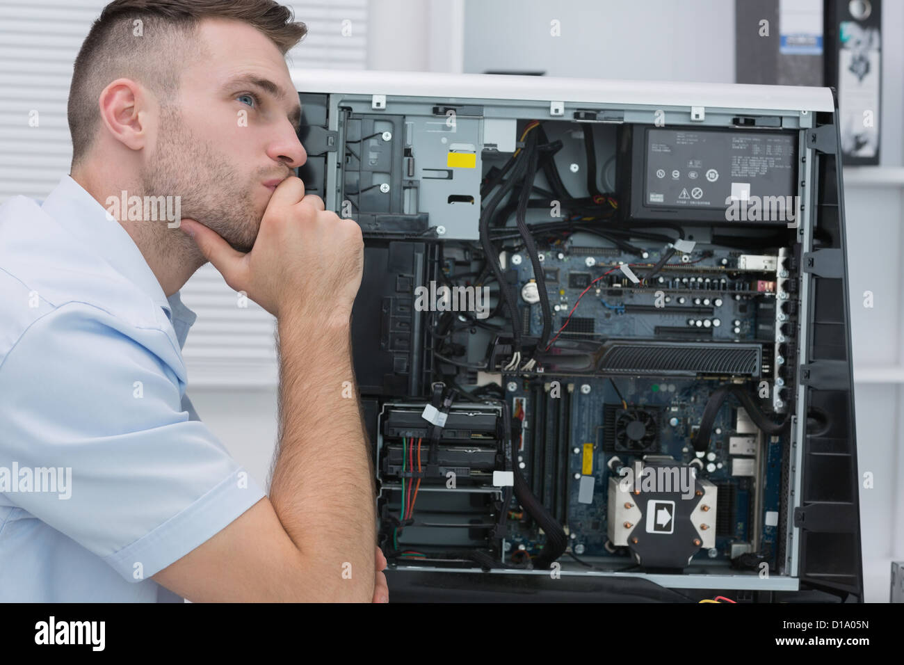 Thoughtful hardware professional by an open cpu Stock Photo - Alamy