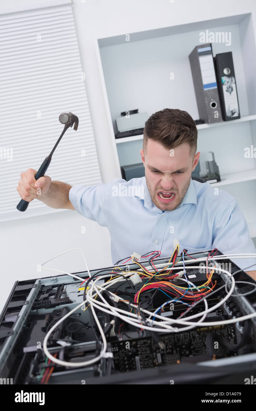 Frustrated man hitting cpu with hammer Stock Photo - Alamy