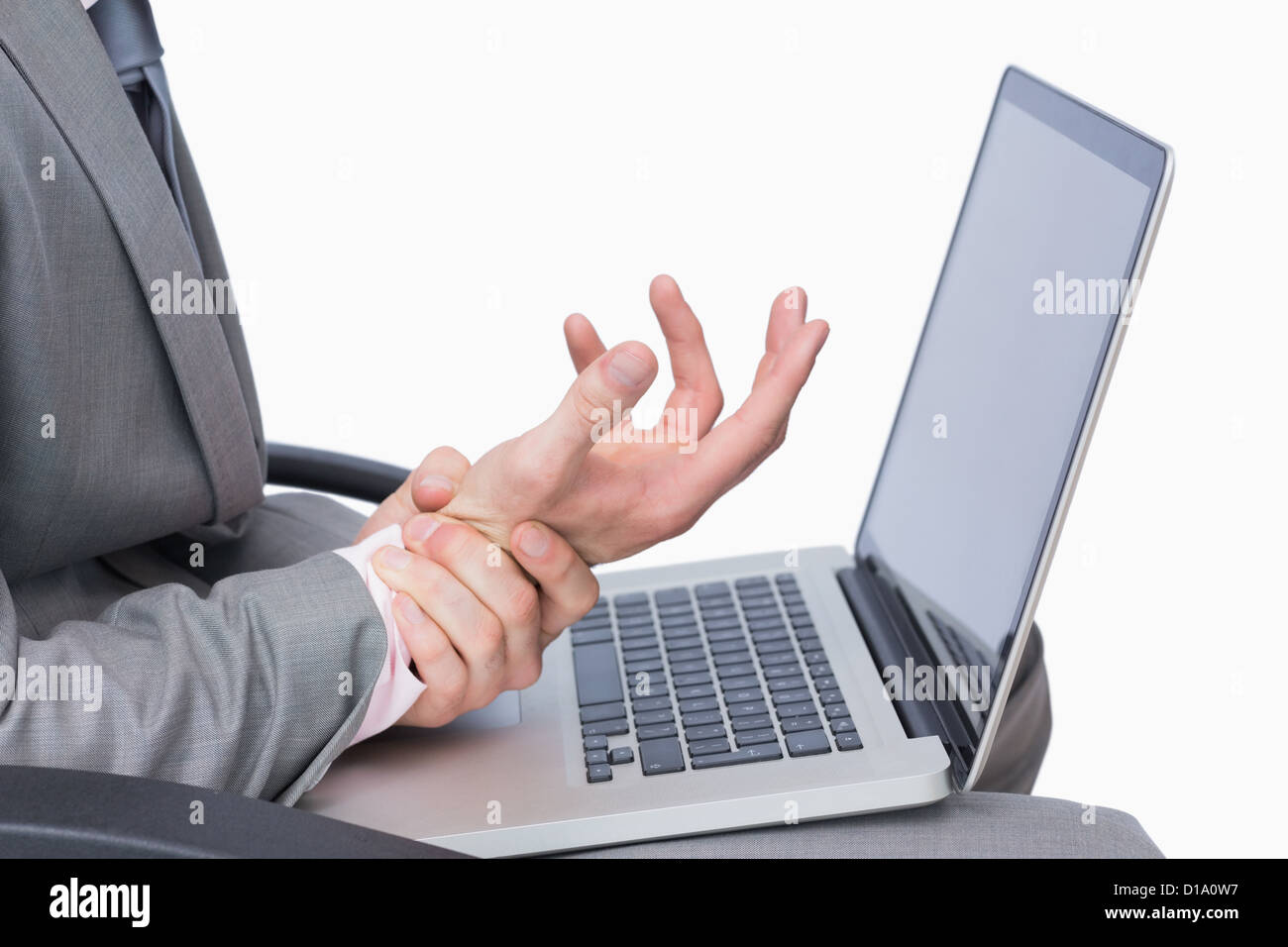 Business man with wrist pain while using laptop Stock Photo - Alamy