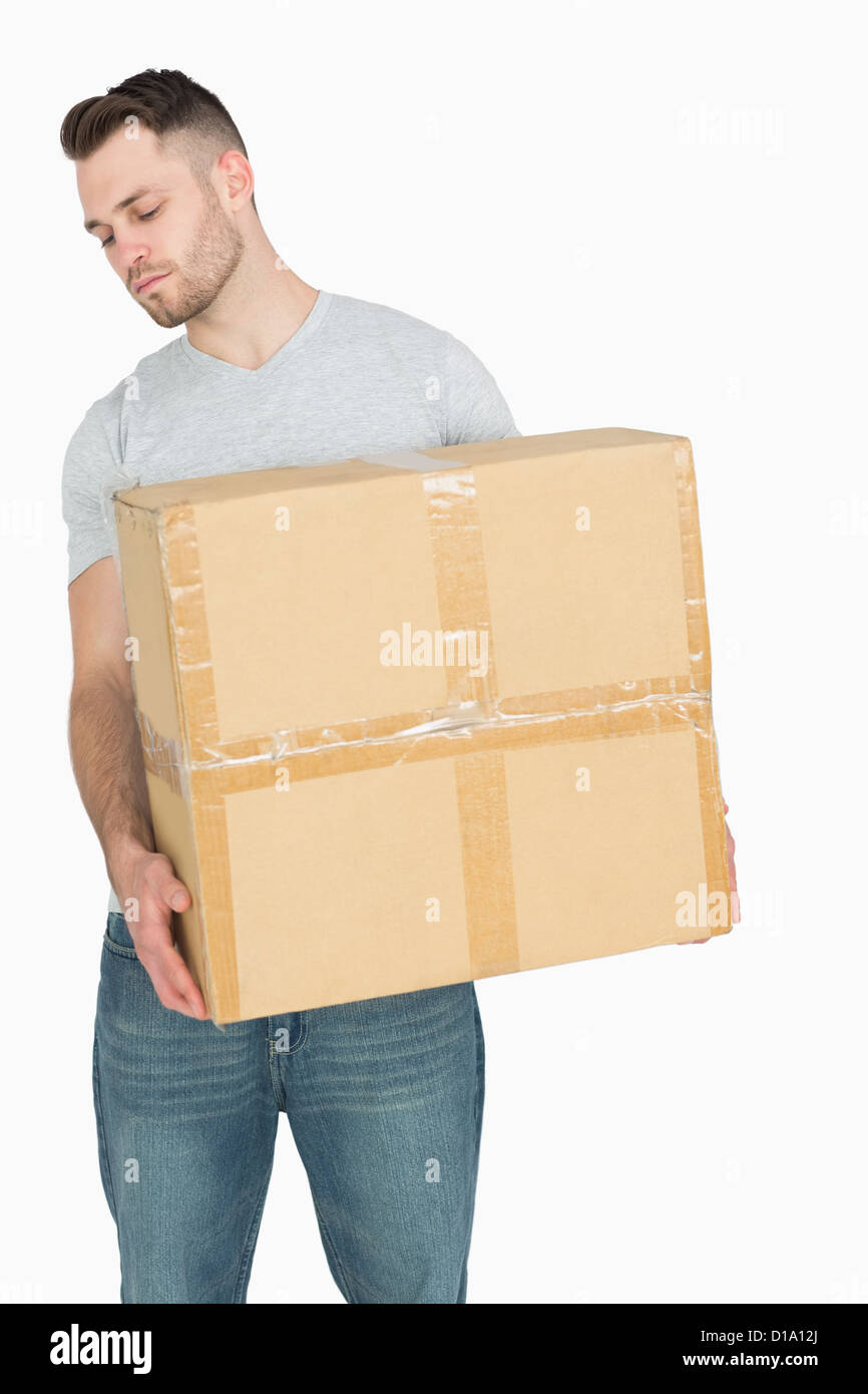 Young casual man carrying cardboard box Stock Photo - Alamy