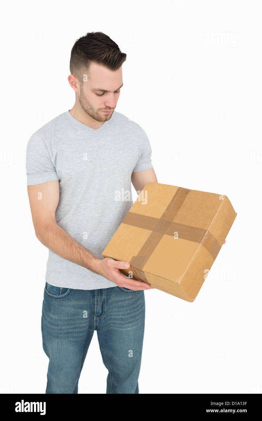 Young casual man carrying cardboard box Stock Photo - Alamy