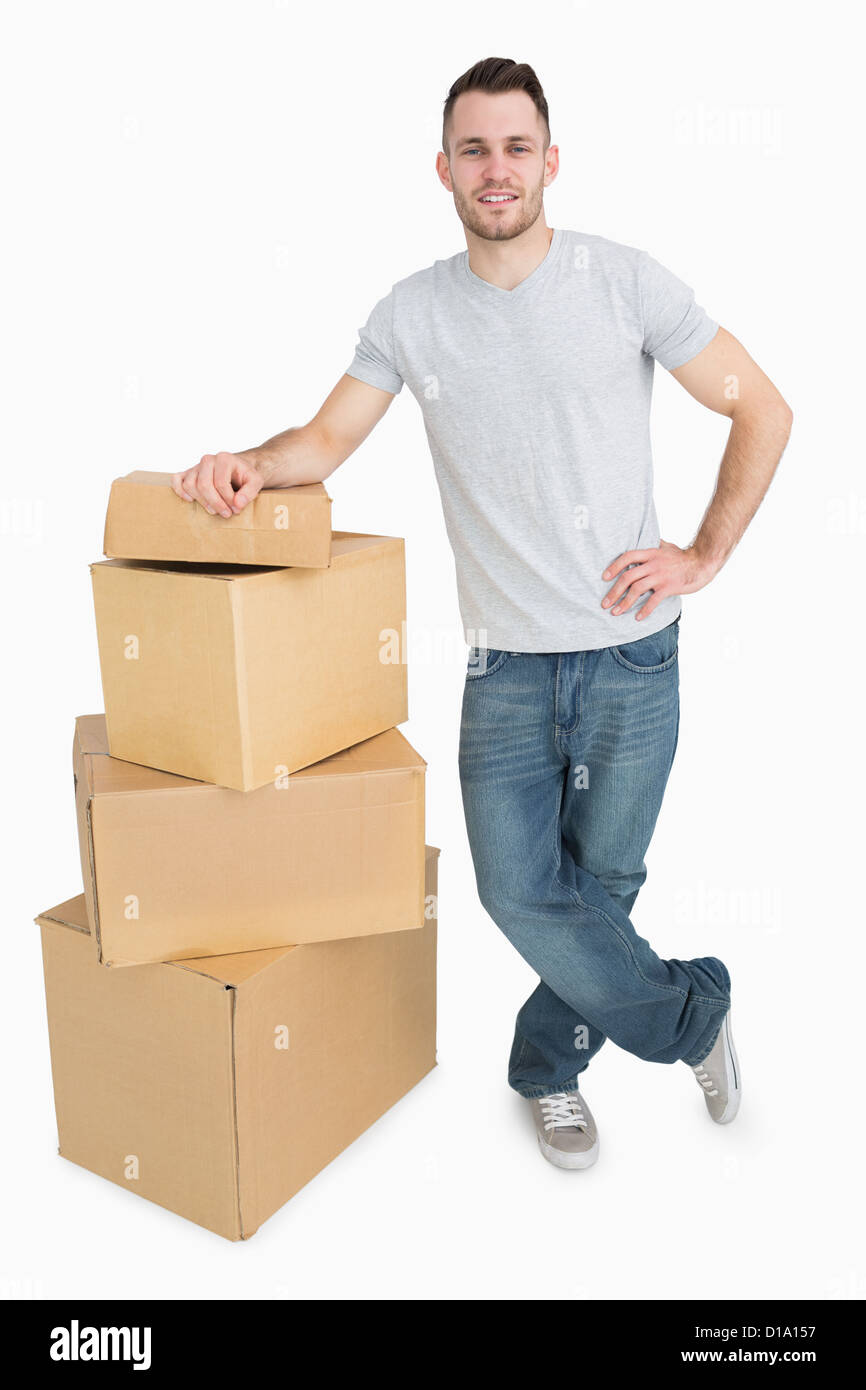 Portrait of smiling young man with cardboard boxes Stock Photo - Alamy