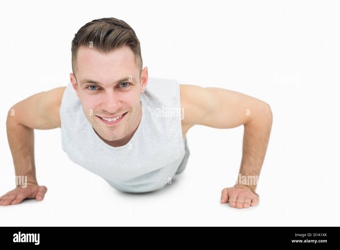 Portrait of smiling young man doing push ups Stock Photo - Alamy