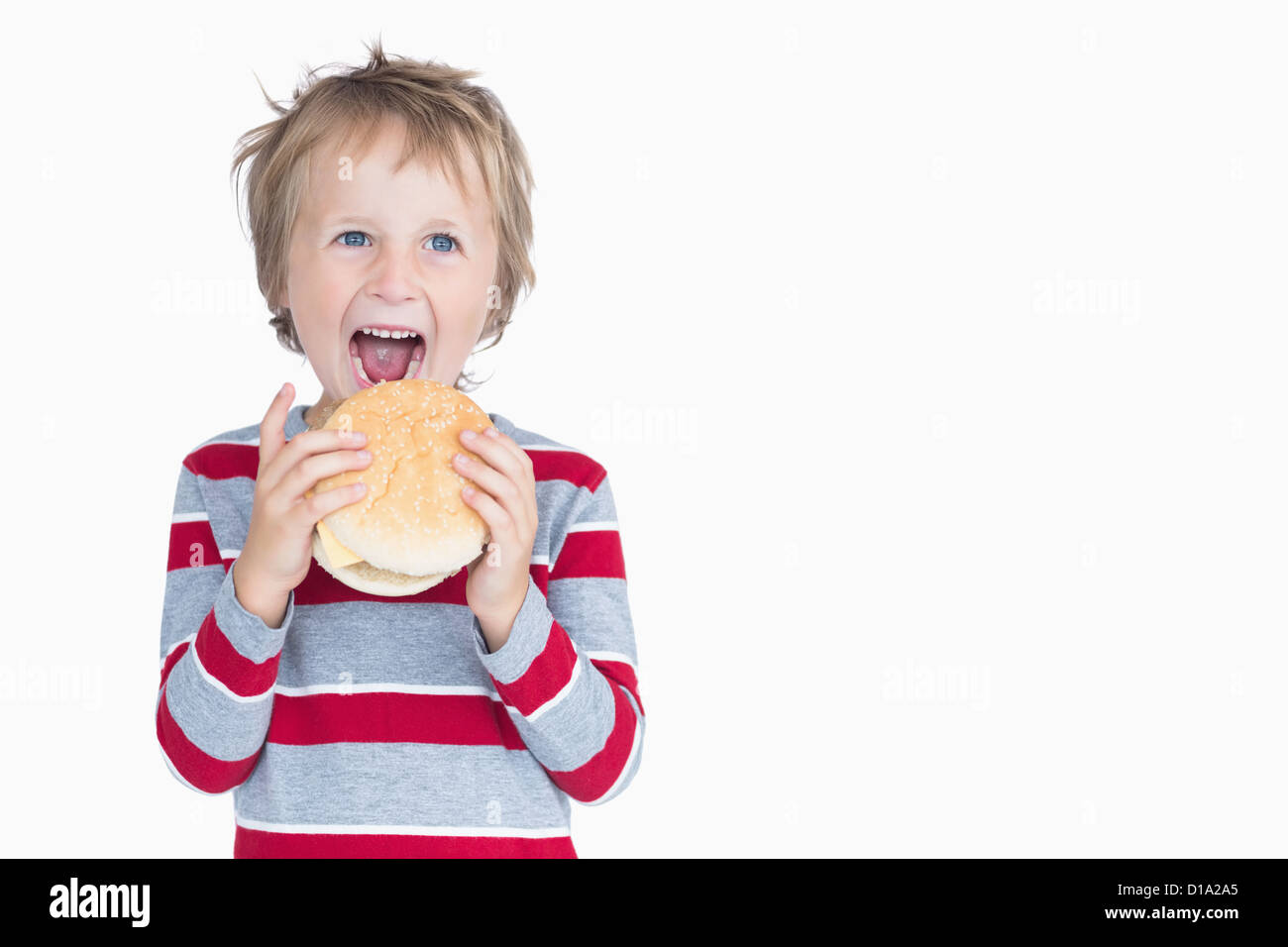 Cheerful young boy eating burger Stock Photo - Alamy