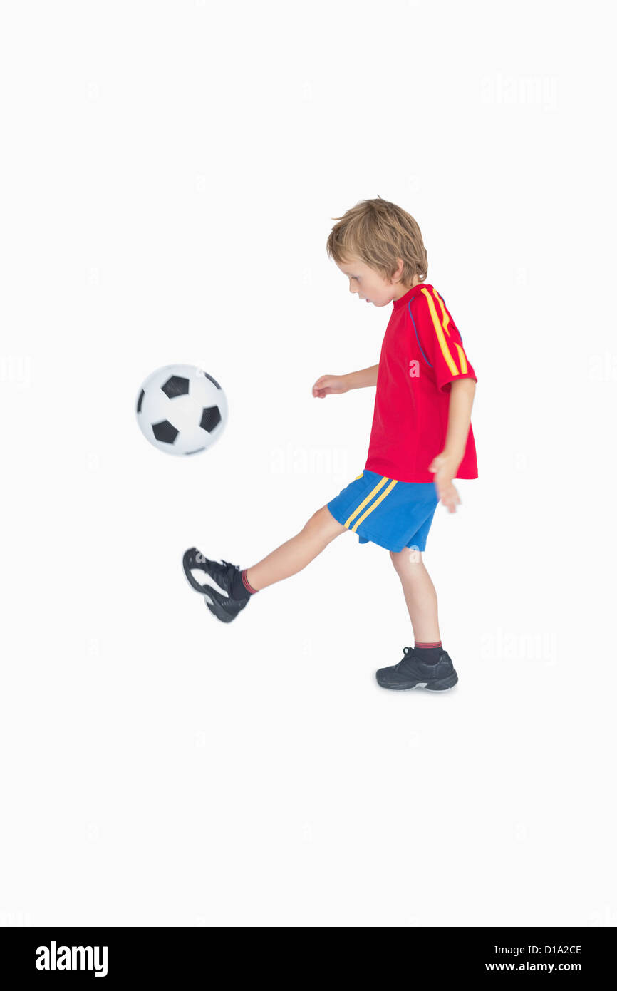 Side view of little boy kicking football Stock Photo - Alamy