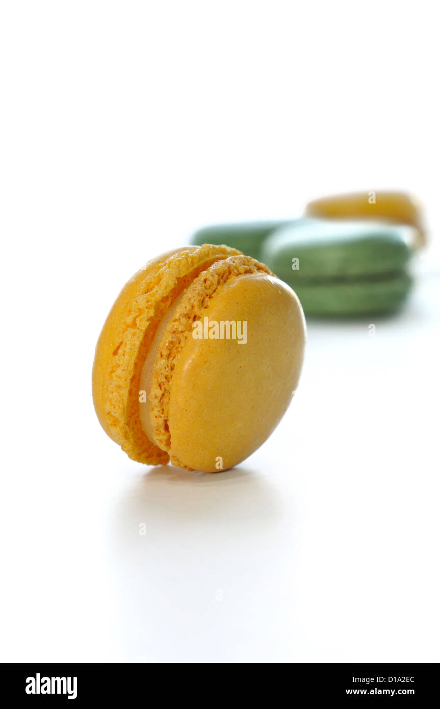 a vanilla macaroon standing in front of others on white background ...