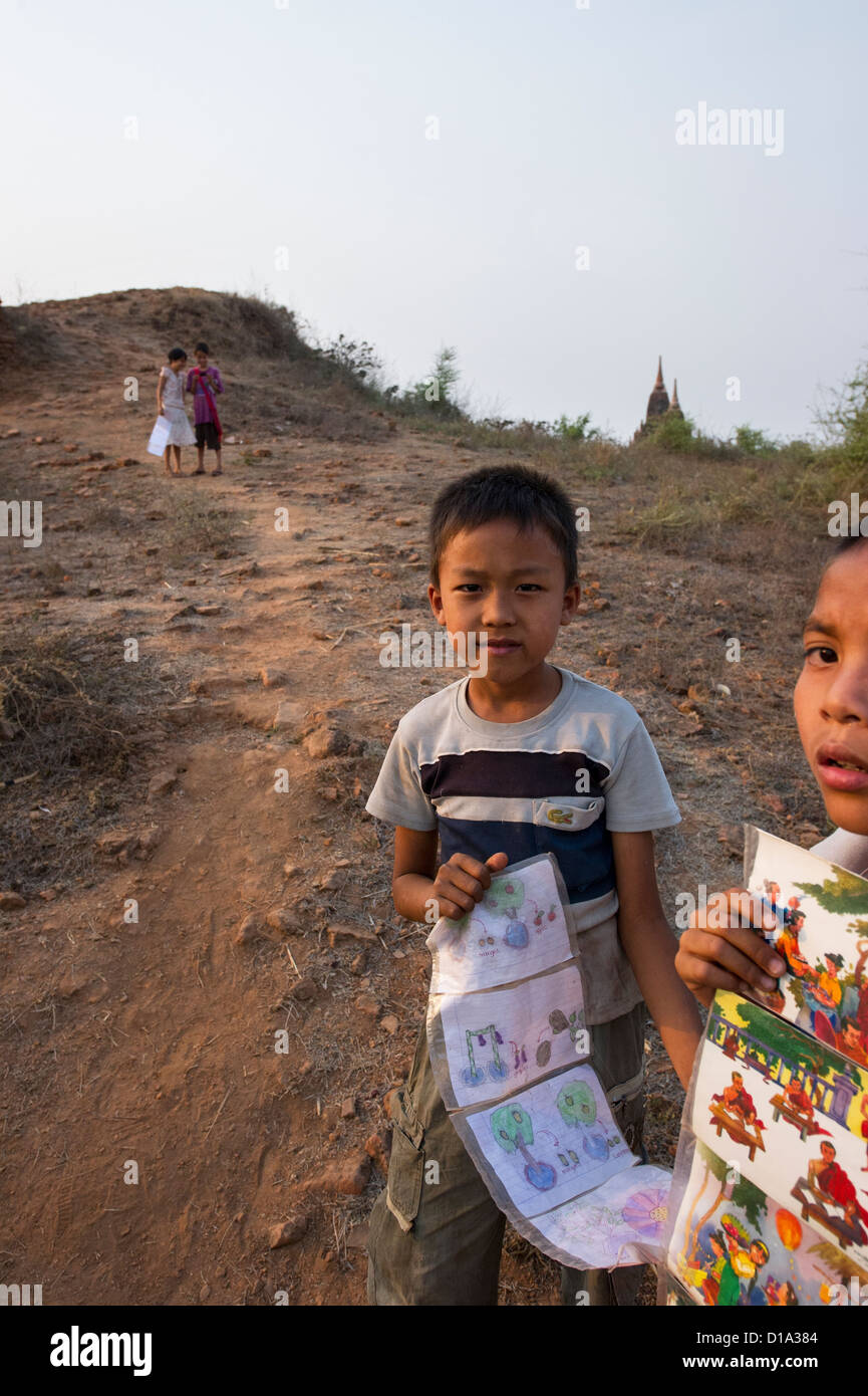 Children selling postcards and artwork to tourists visiting in Bagan ...