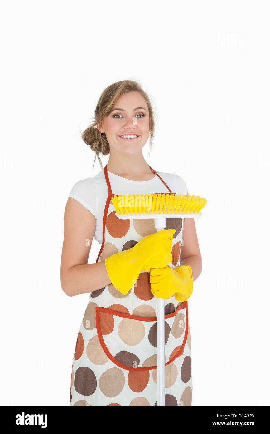Portrait of smiling young woman with broom Stock Photo - Alamy