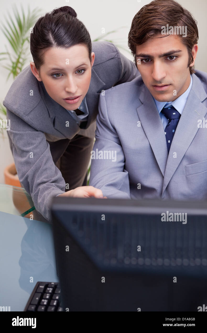 Colleagues looking at computer screen in office Stock Photo - Alamy
