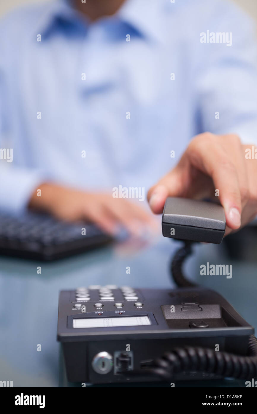 Closeup of man with telephone receiver at desk Stock Photo - Alamy