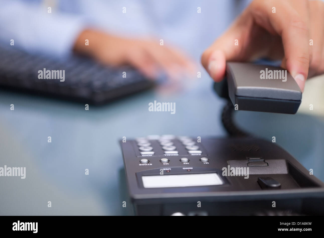 Man with telephone receiver at desk Stock Photo - Alamy