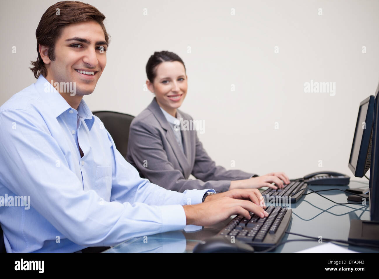 Colleagues using computers at office Stock Photo - Alamy