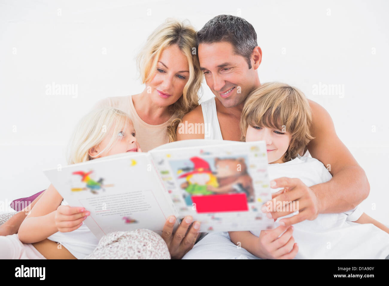 Happy family reading a story together Stock Photo - Alamy