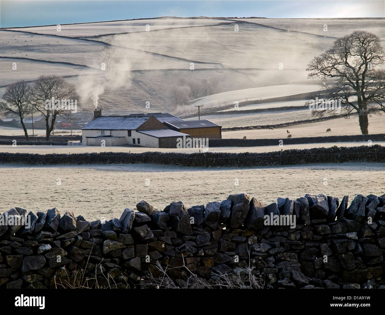Smoke rising from a farmhouse chimney.Cold December morning in the Peak ...