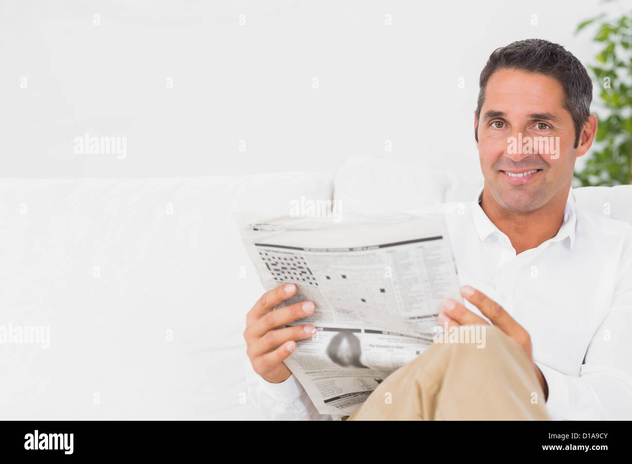 Smiling man reading a newspaper Stock Photo - Alamy
