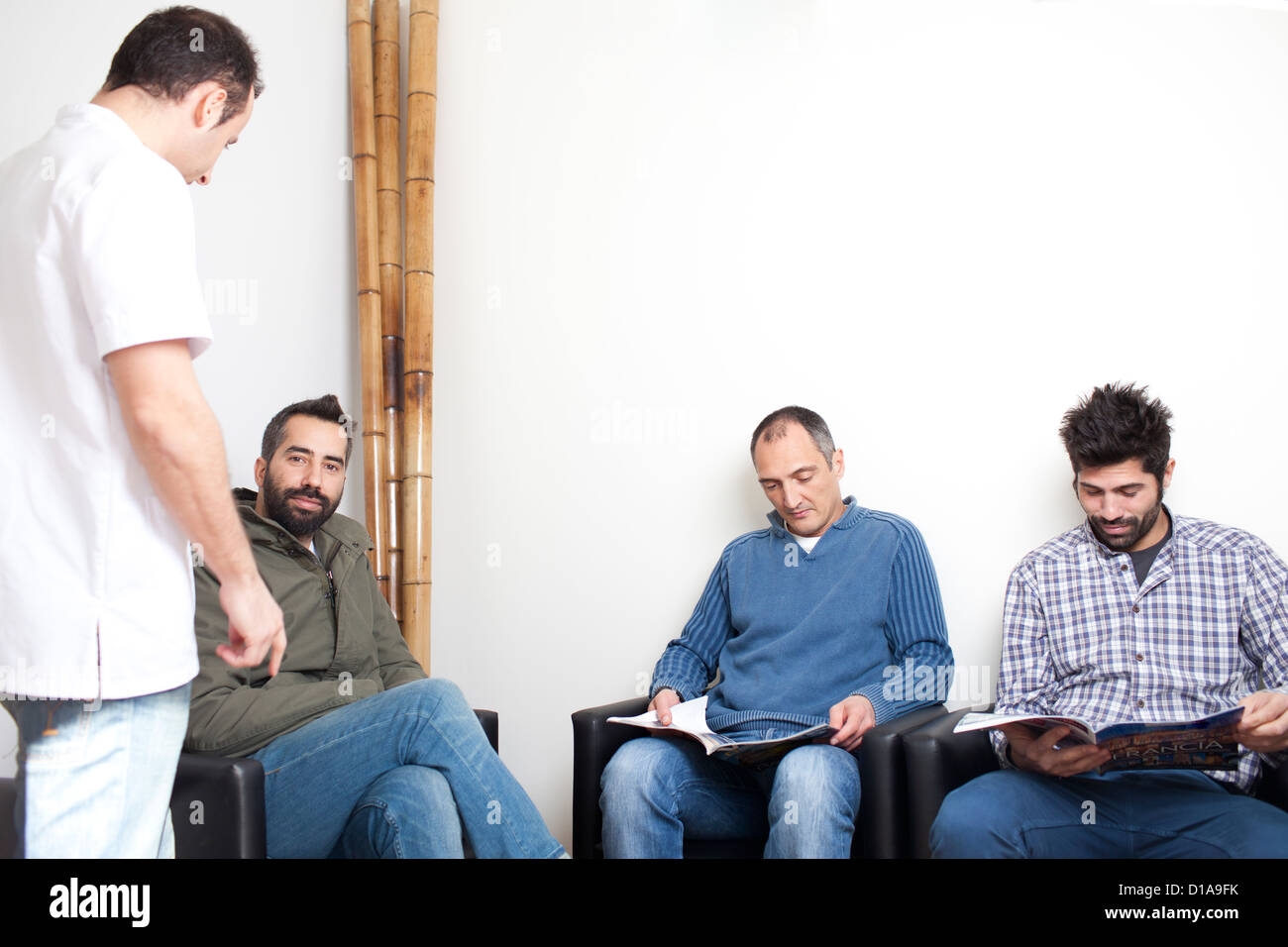 Doctor saying hello to patient in waiting room Stock Photo - Alamy