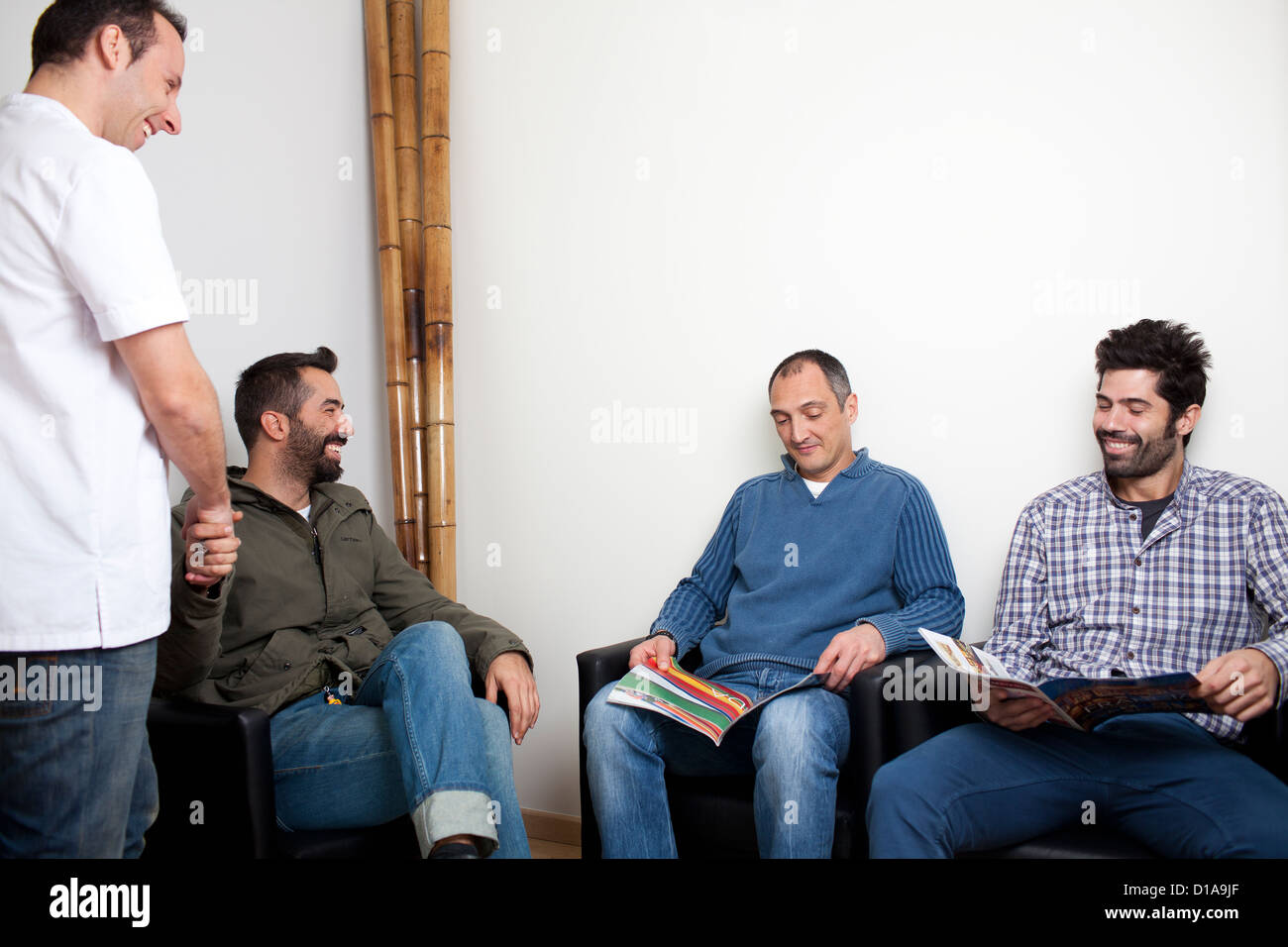 Doctor saying hello to patient in waiting room Stock Photo - Alamy