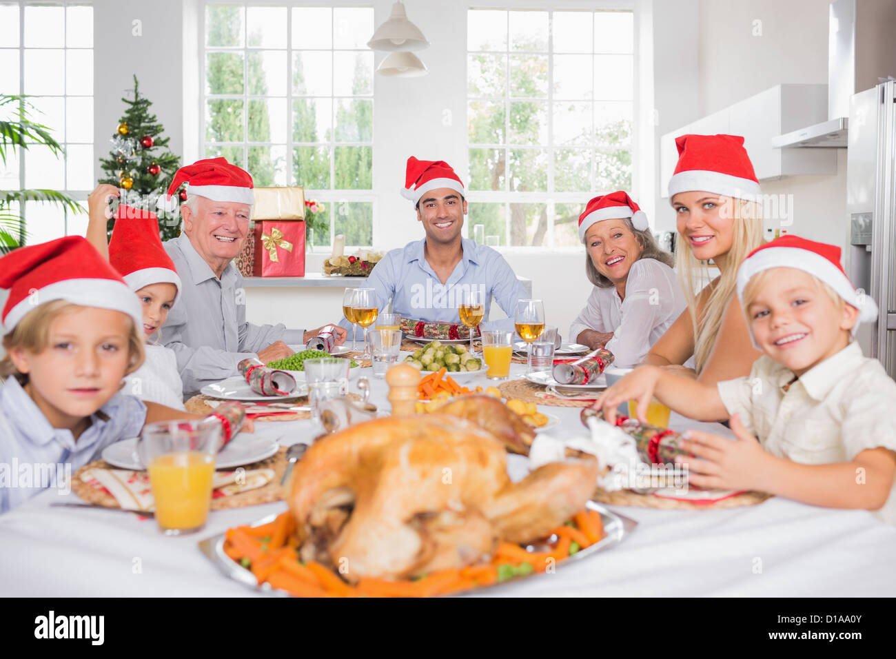 Smiling family around the dinner table at christmas Stock Photo - Alamy
