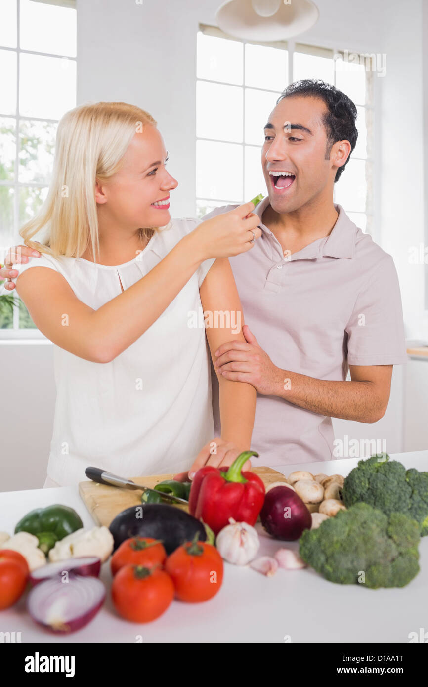 Wife giving vegetable to her husband Stock Photo - Alamy