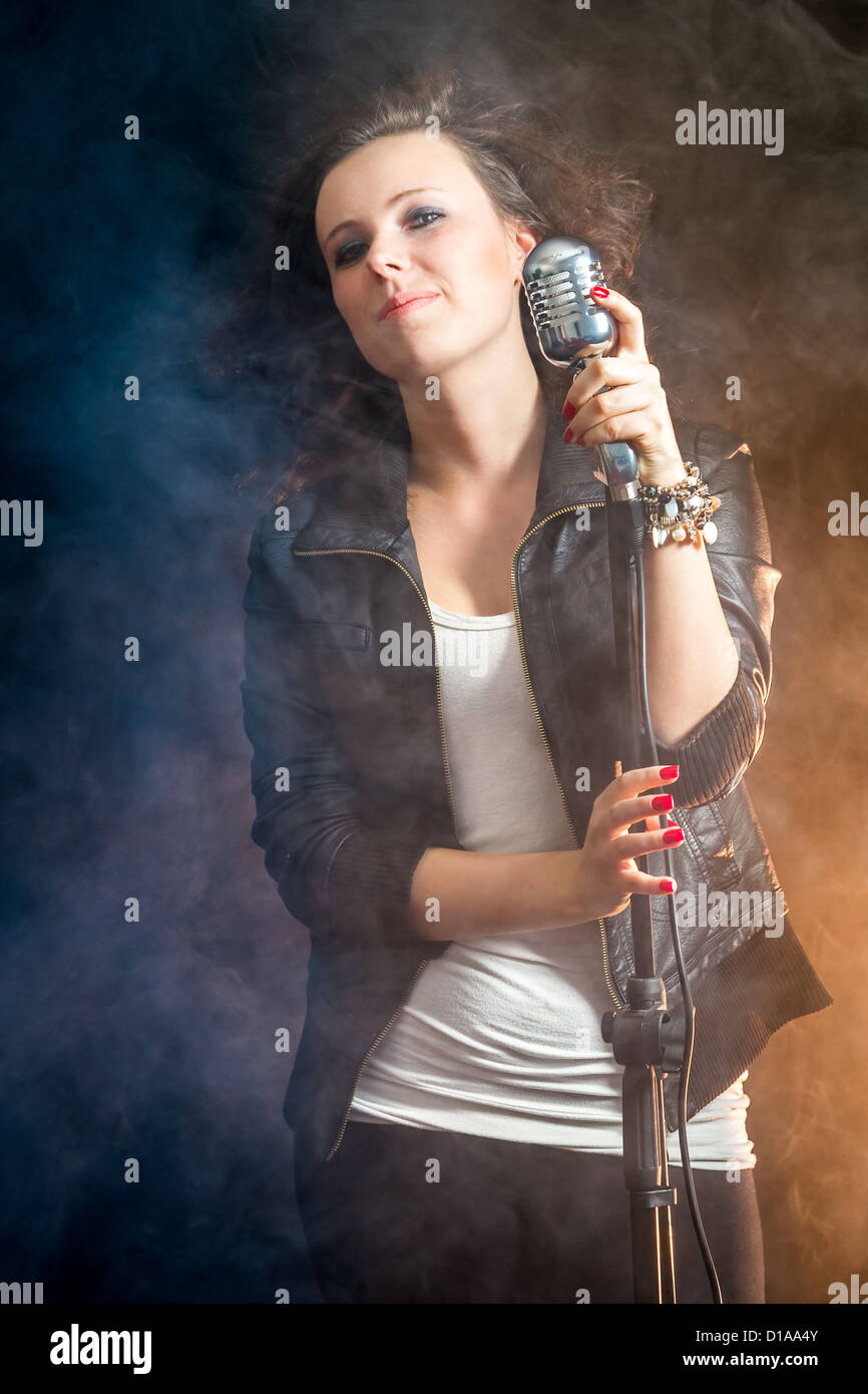 Beautiful singer with microphone on stage Stock Photo - Alamy