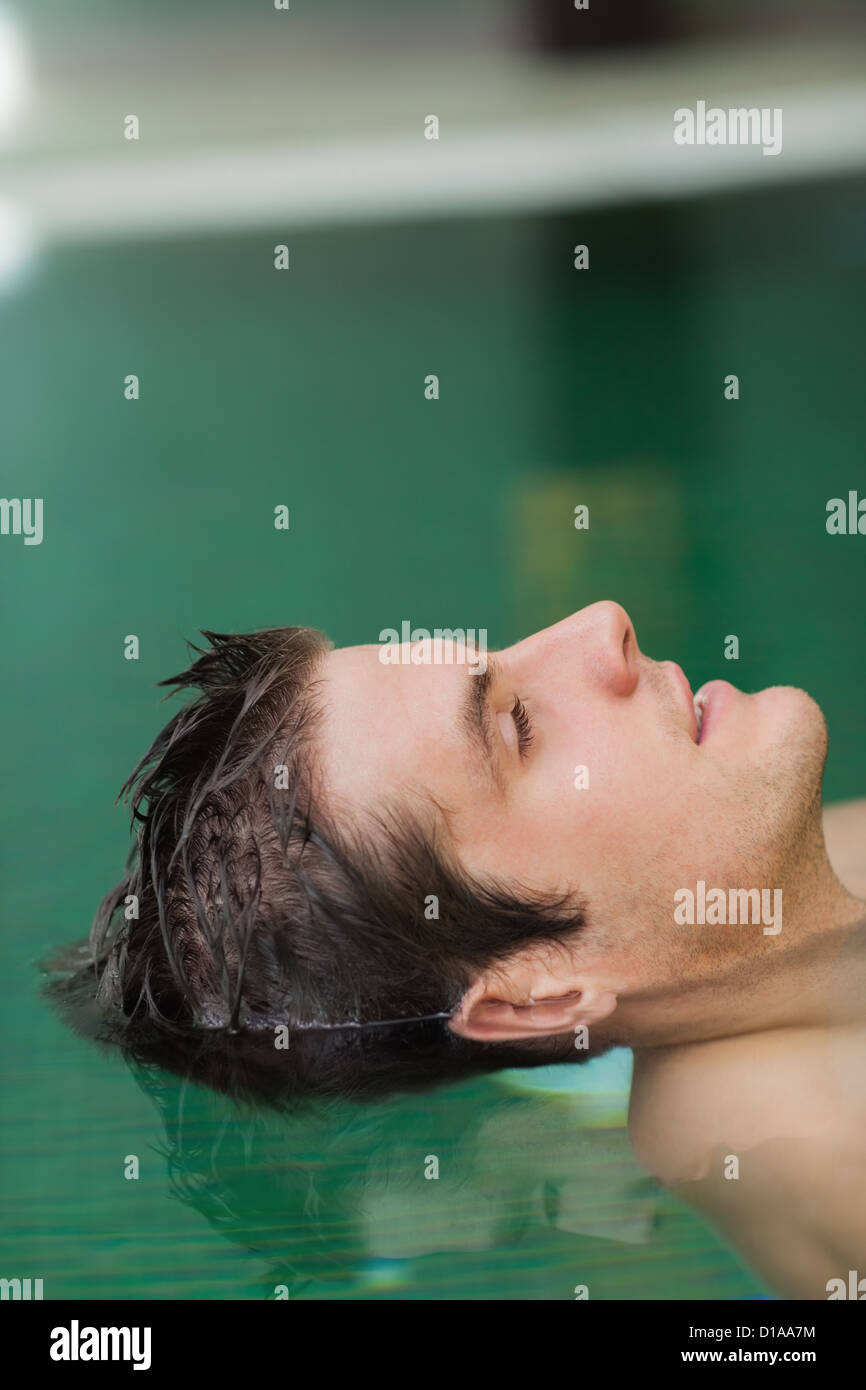 Relaxed man floating in pool Stock Photo - Alamy