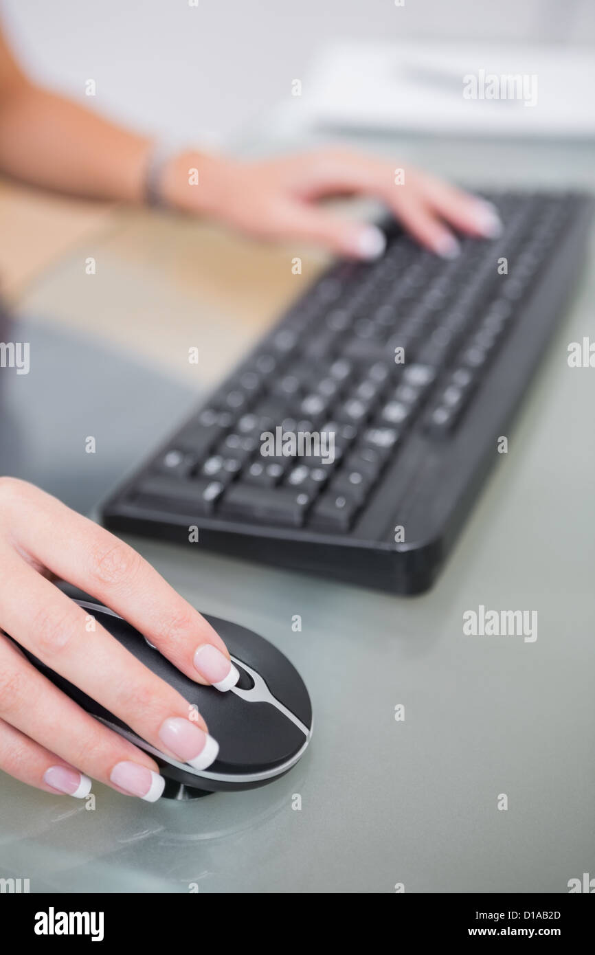 Hands using computer mouse and keyboard at office desk Stock Photo - Alamy