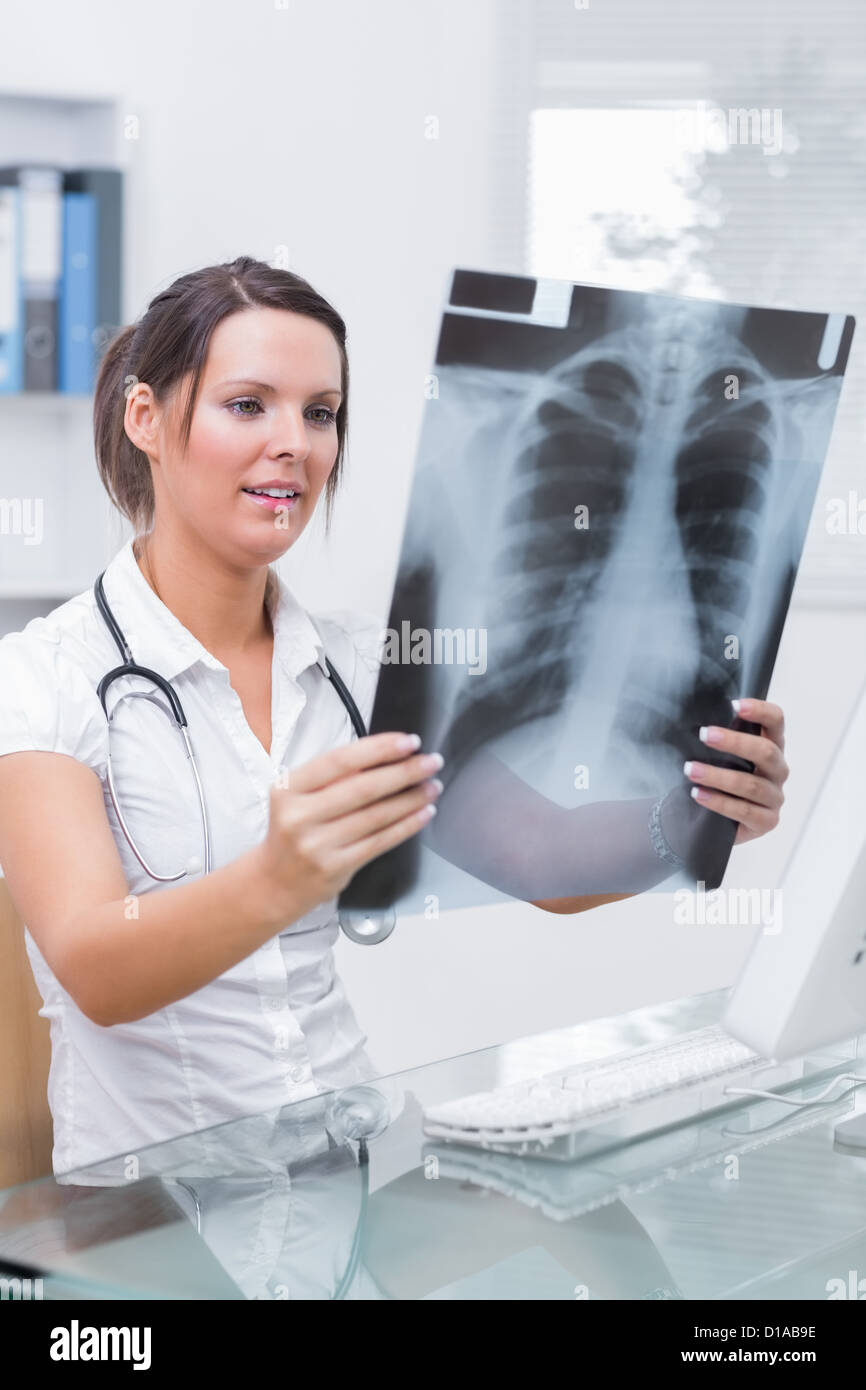 Doctor with x-ray sitting in front of computer at clinic Stock Photo ...