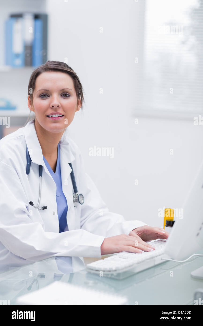 Confident female doctor using computer at clinic Stock Photo - Alamy