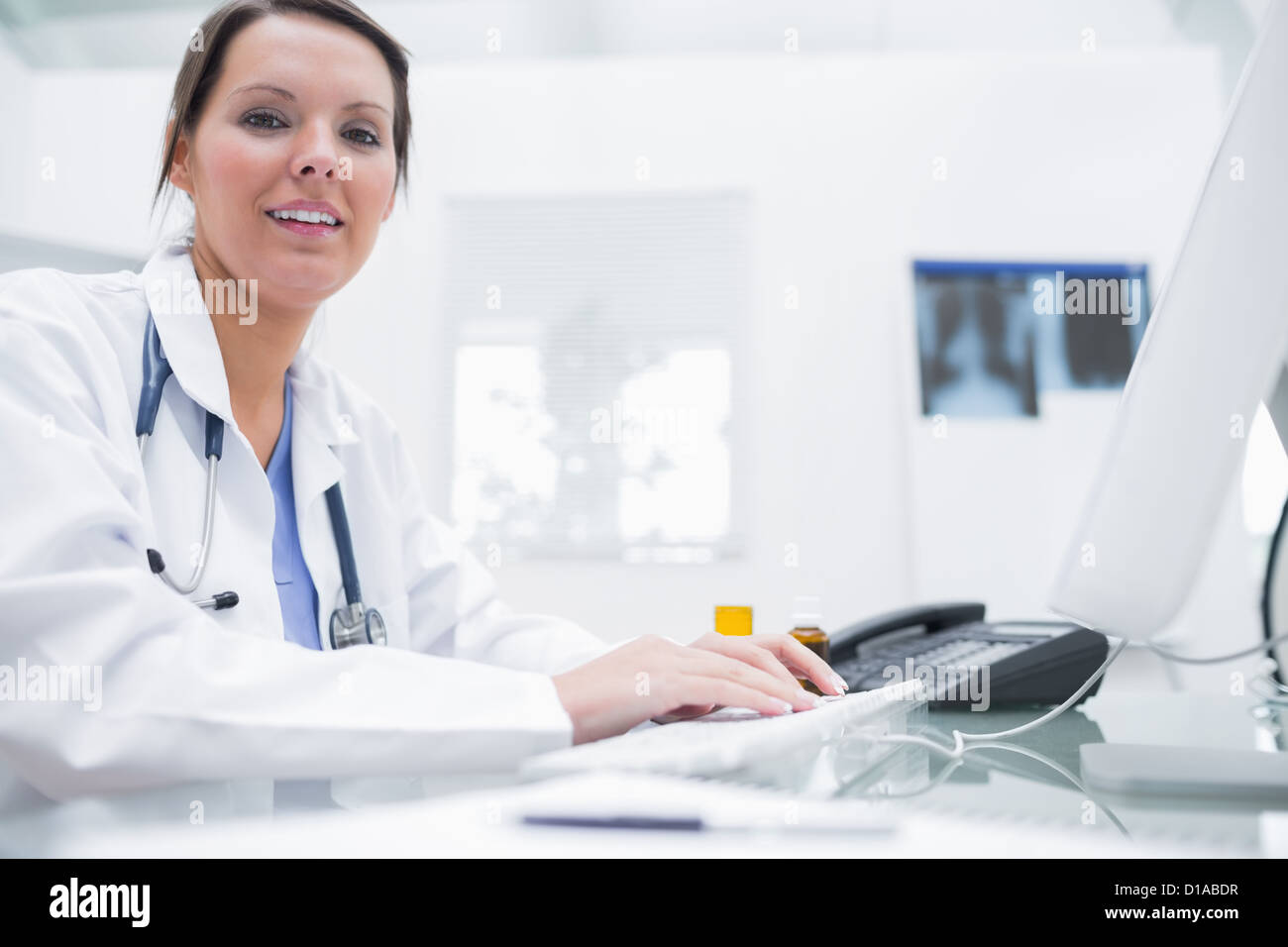 Portrait of smiling doctor using computer at clinic Stock Photo - Alamy