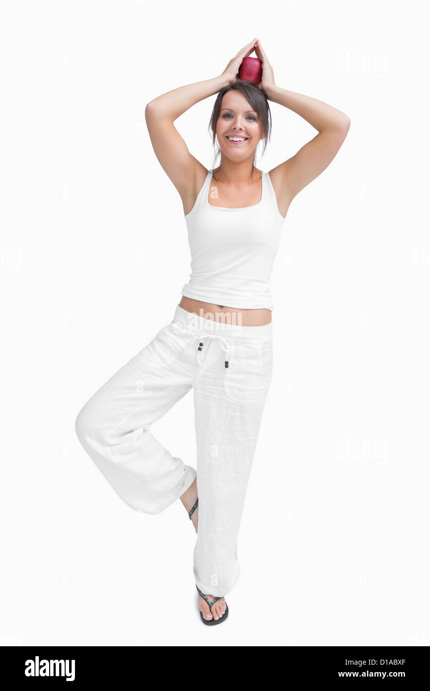 Portrait of woman doing the tree pose and holding apple Stock Photo - Alamy