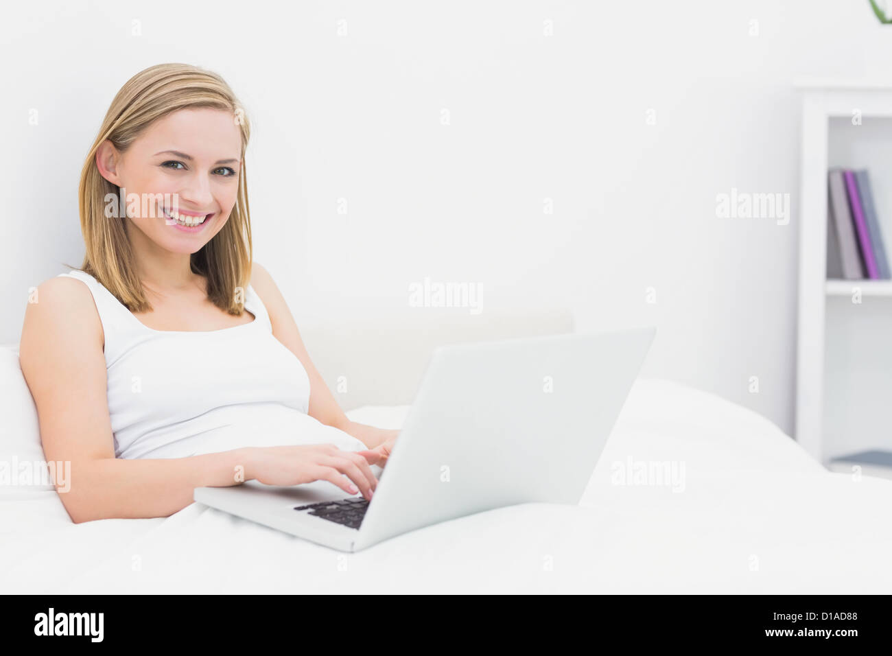 Portrait of happy woman using laptop in bed Stock Photo - Alamy